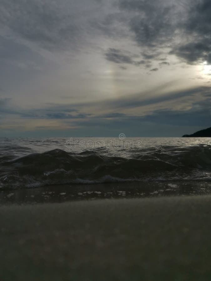 Low Angle Shot from the Beach Towards the Incoming Sea Tide at Evening ...