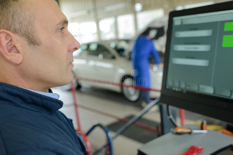 Image Male Mechanic Checking Tires on Computer Stock Photo - Image of ...