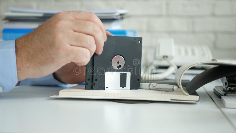 Image with Man Hand in Office Room Using a Floppy Disk Stock Image ...