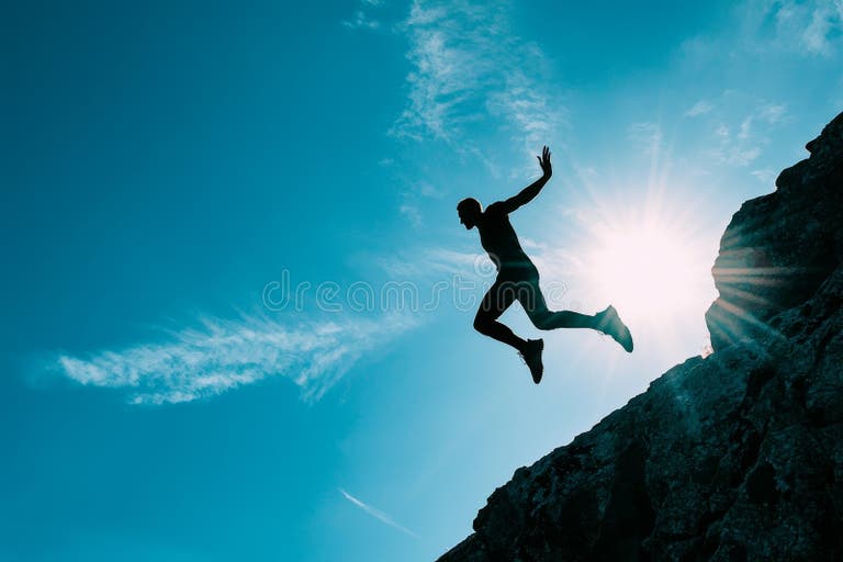 An Image of a Man Jumping between Cliffs and a Bright Sky in the ...