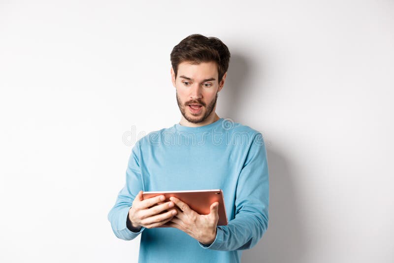Image of Man Looking Curious at Digital Tablet, Reading Interesting ...