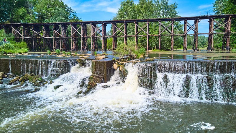 Manmade Dam Creating Waterfalls with Railroad Wood Bridge in Background ...