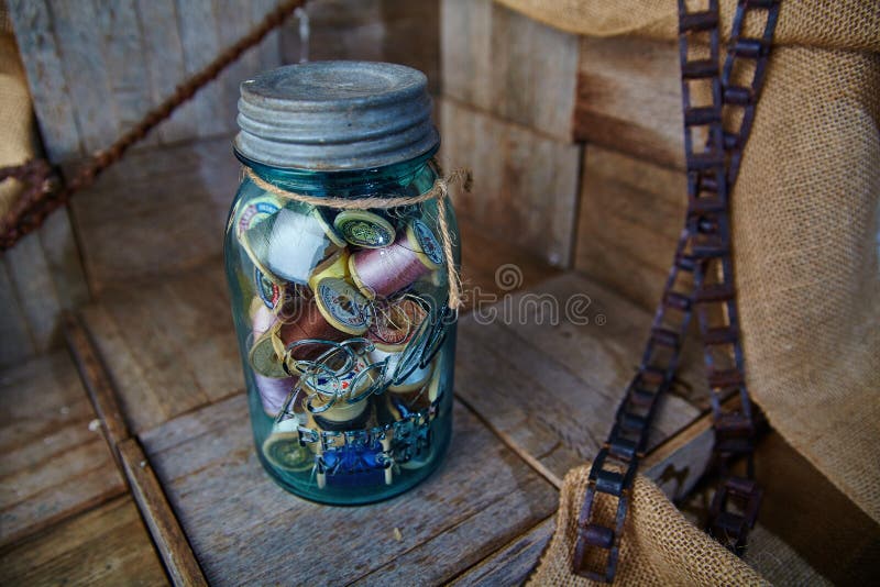 Mason Jar Full of Spools of Thread Sitting on a Wooden Surface Stock ...