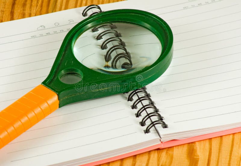 Image of Notebook and Magnifying Glass on a Table Close-up Stock Photo ...