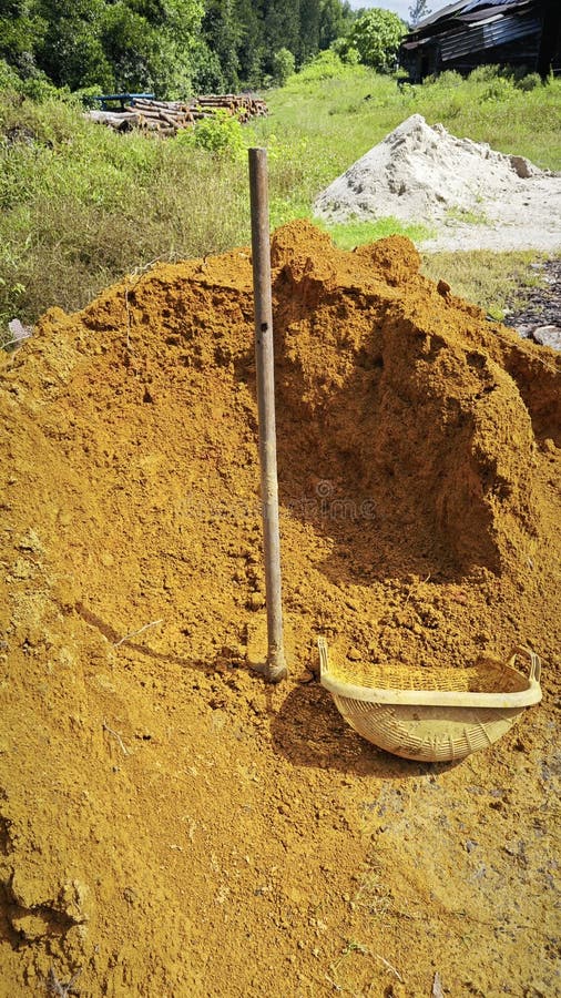 An Old Hoe and Soil Scooping Basket by the Pile of Brown Soil. Stock ...