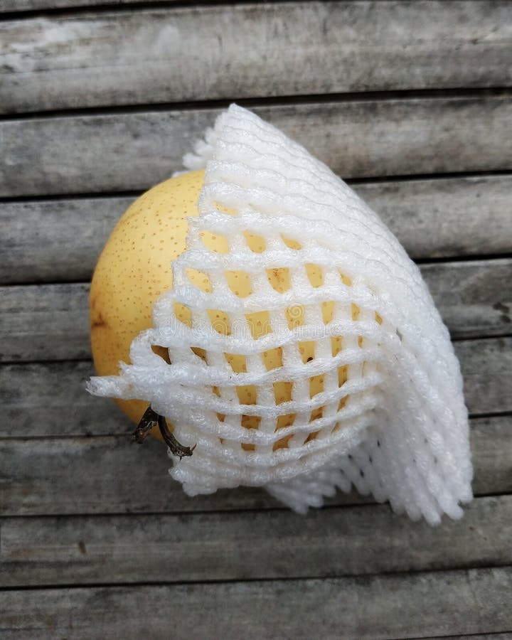 Pear Fruit Wrapped in a Fruit Net on a Black Leather Board Stock Photo ...