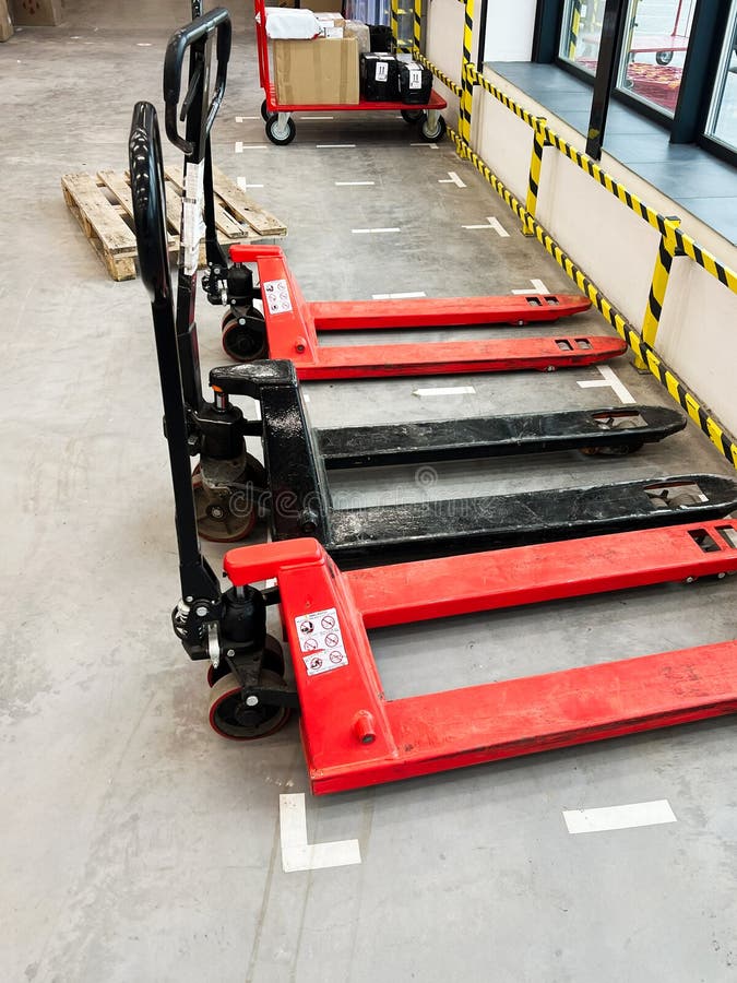 Industrial Warehouse with Red Pallet Jacks and Loaded Carts in Storage ...