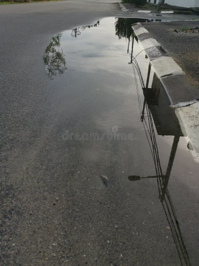 Reflective Puddle with Stagnant Water on the Roadside after the Rain ...