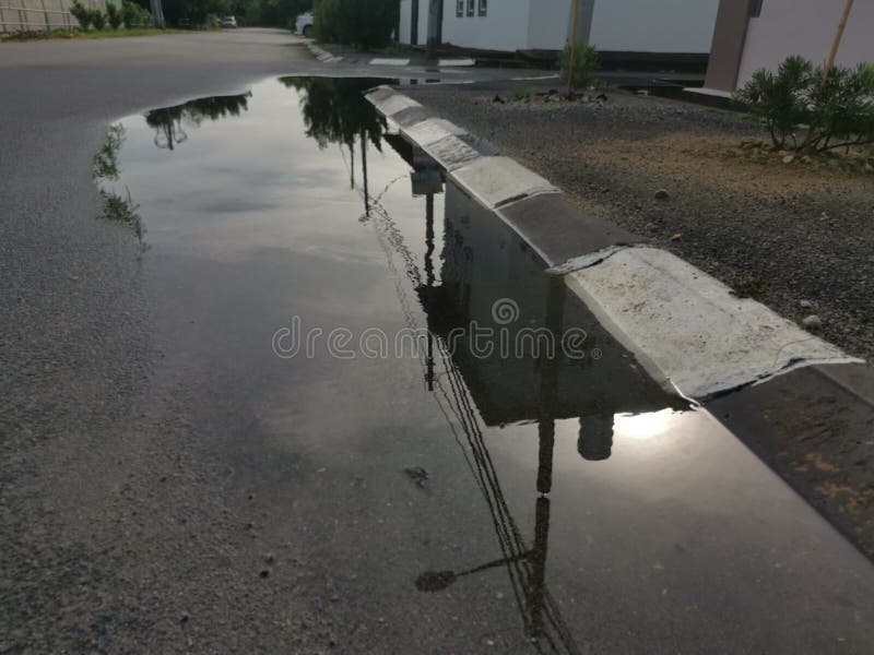Reflective Puddle with Stagnant Water on the Roadside after the Rain ...