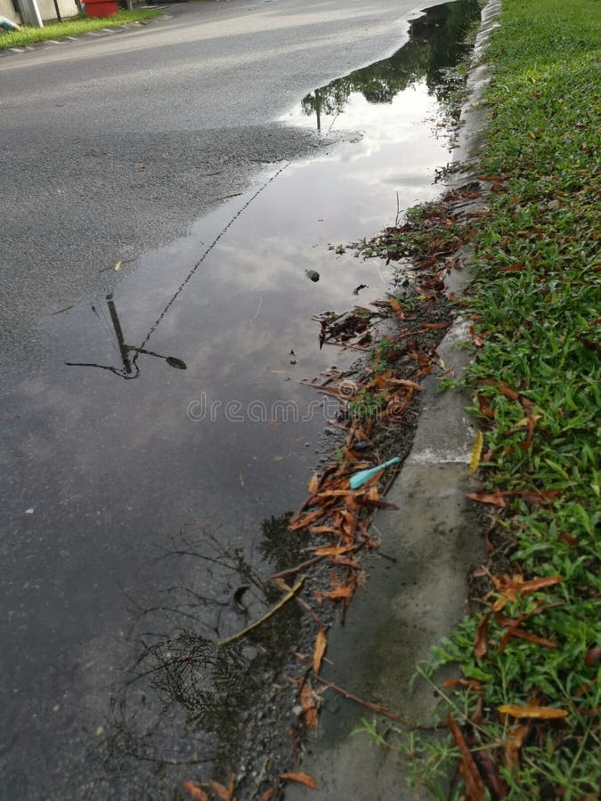 Reflective Puddle with Stagnant Water on the Roadside after the Rain ...