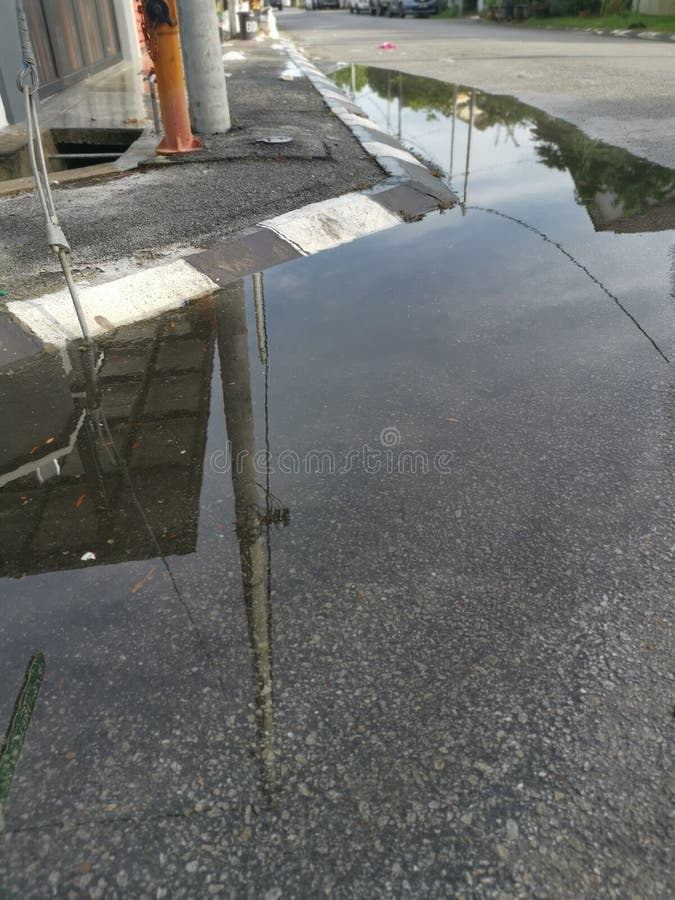 Reflective Puddle with Stagnant Water on the Roadside after the Rain ...