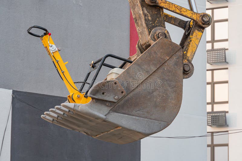 Image Showcases an Excavator in Mid-air Against a Construction Backdrop ...