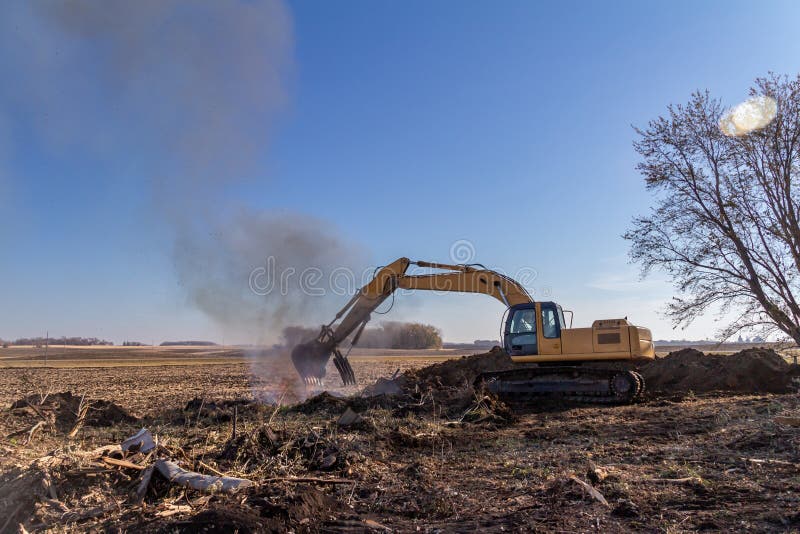 Excavator Machinery Moving Trees and Debris into a Fire Pit Stock Photo ... Excavator Machinery Moving Trees and Debris into a Fire Pit Stock Photo ...