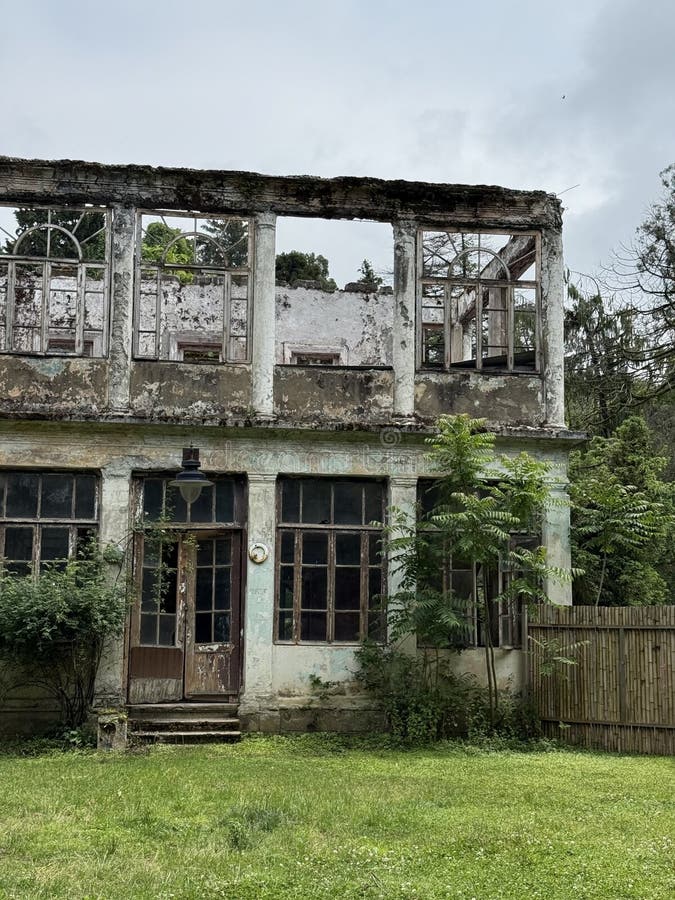 Old, Ruined Building with Broken Doors and Windows, Surrounded by Grass ...