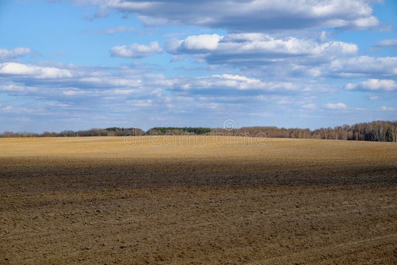 The Image Shows an Expansive Ploughed Field Under a Cloudy Sky Stock ...