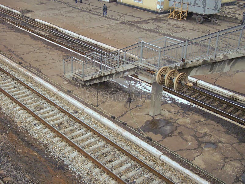 Image Shows an Outdoor Scene with Rusted Railway Tracks, a Mechanical ...