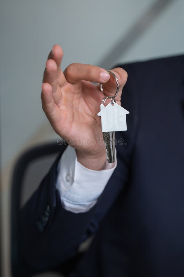 Hand Holding Silver House Key with House-shaped Keychain on White ...