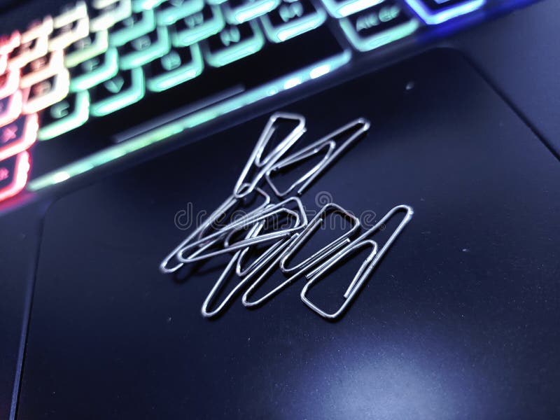 The Image Shows Several Silver Paper Clips Scattered on a Black Surface ...