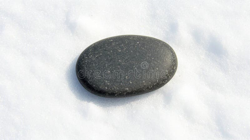 A Black Pebble in the Snow. Stock Photo - Image of pebble, single ...