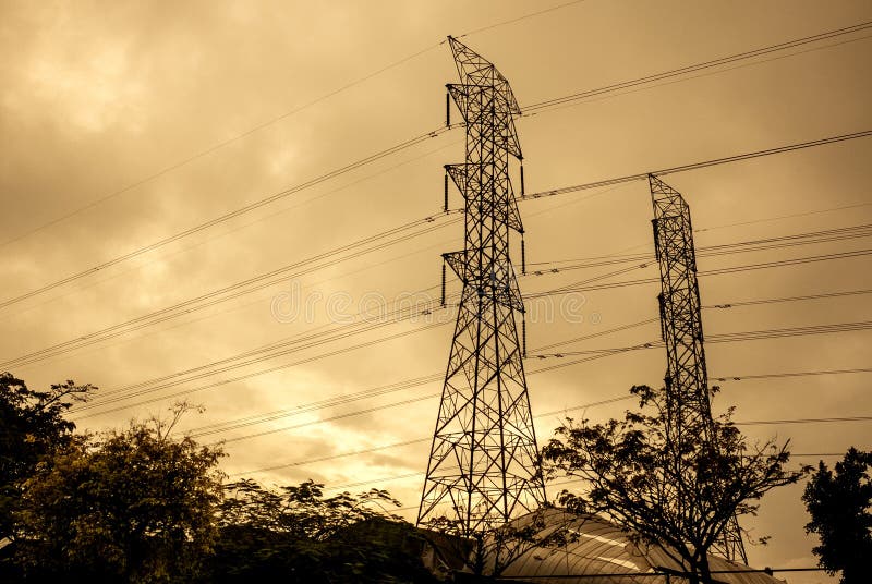 The Image Shows Two Electrical Transmission Towers Silhouetted Against ...