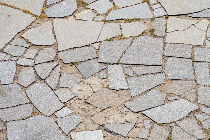 Image Shows a Worn, Interlocking Stone or Concrete Tile Surface with a ...