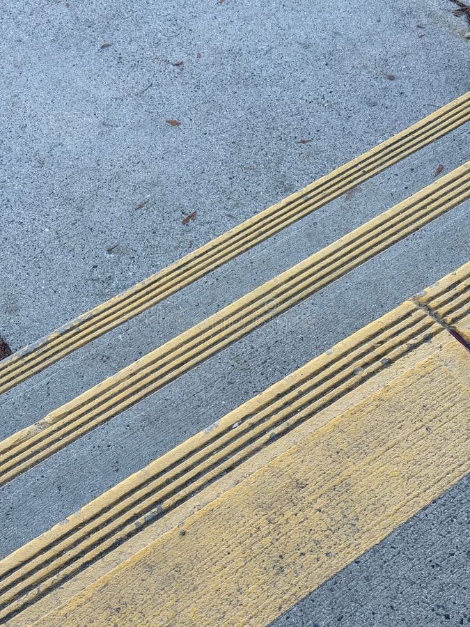 Two Lines Painted in the Middle of a Sidewalk that is Yellow Stock ...