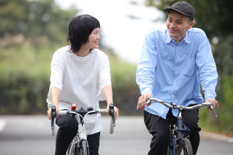 A Smiling Couple Riding a Bicycle Stock Photo - Image of bright, sunny ...