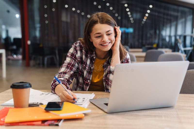 Image of Smiling Girl Doing Homework with Laptop and Exercise Books ...