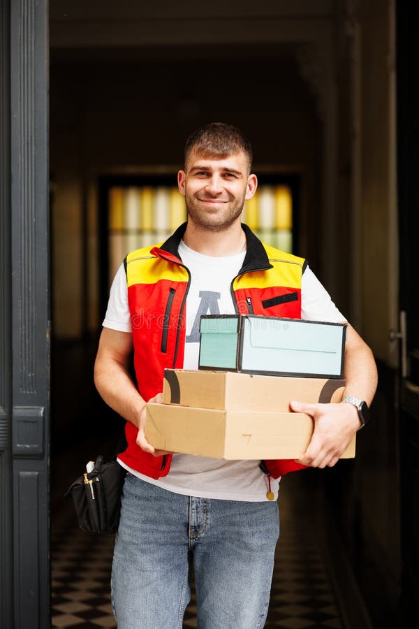 Image of Smiling Young Delivery Man Standing with Parcel Box Stock ...