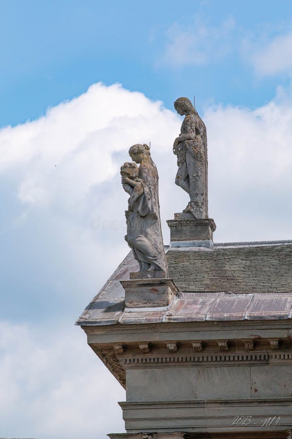 Image of a Stunning Rooftop View Featuring Three Statues Perched on Top ...