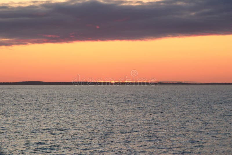 Image of the Sun Setting in the Sea Behind the Island Stock Image ...