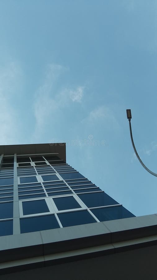 Image of a Tall Office Building with Pole Lights with a Bright Blue Sky ...