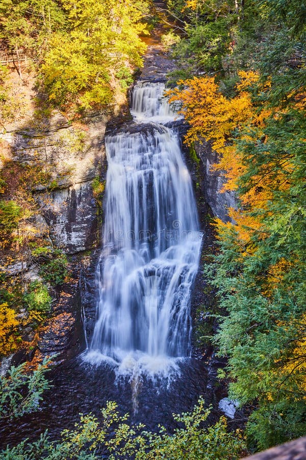 Vertical Close of Large Waterfall from Above Surrounded by Cliffs and ...
