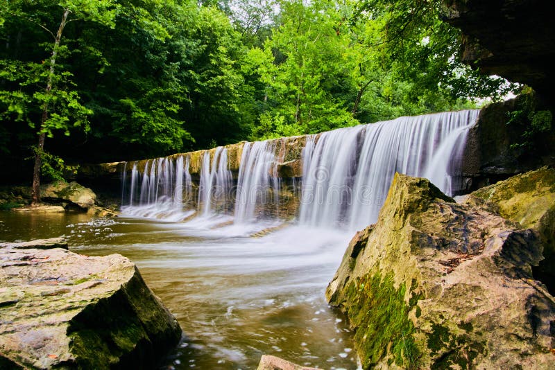 View of Waterfalls Over Cliffs between Two Large Boulders Stock Image ...