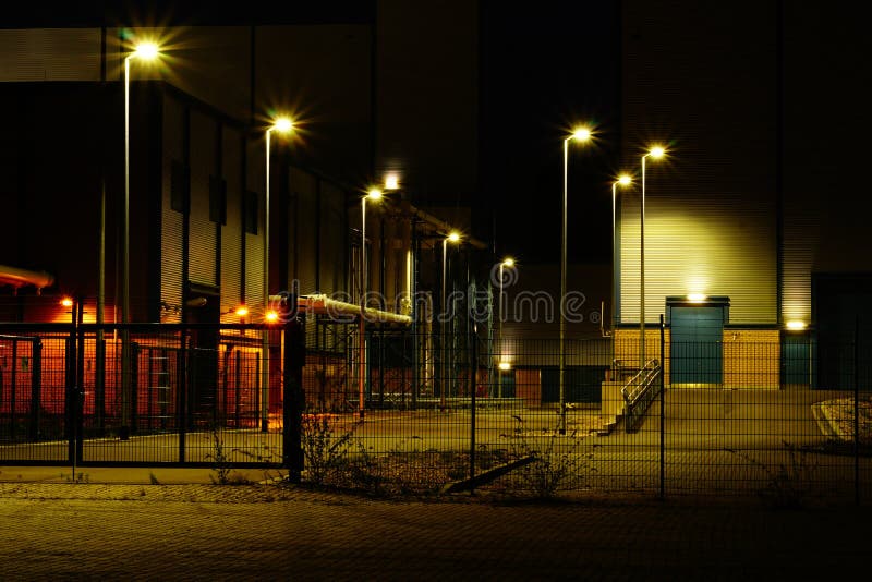 Image of a Well Lit Gated Lot Behind Buildings at Night Stock Photo ...