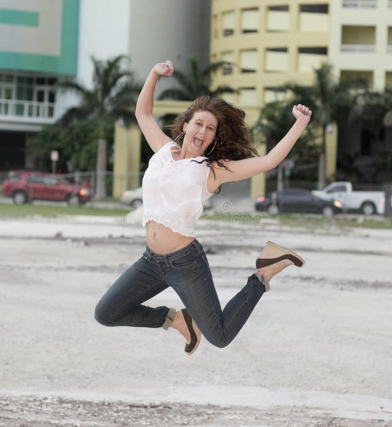 Image of a Woman Jumping and Smiling Stock Photo - Image of jeans ...