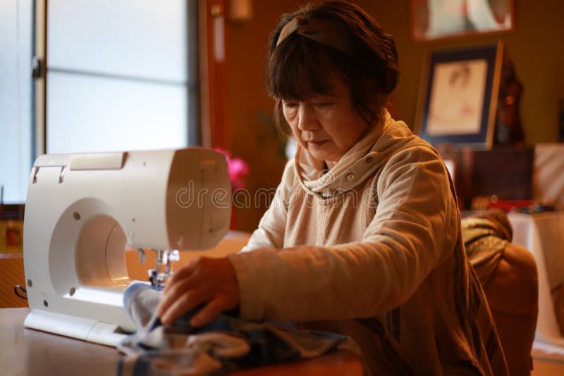Woman Using a Sewing Machine Stock Photo - Image of indoors, living ...