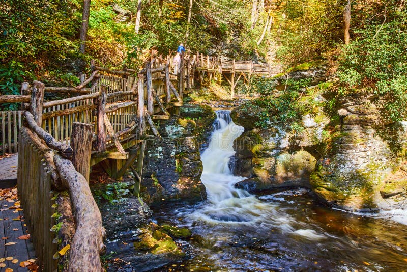 Wood Boardwalk with Natural Railing Along Gorge with Small Waterfall in ...