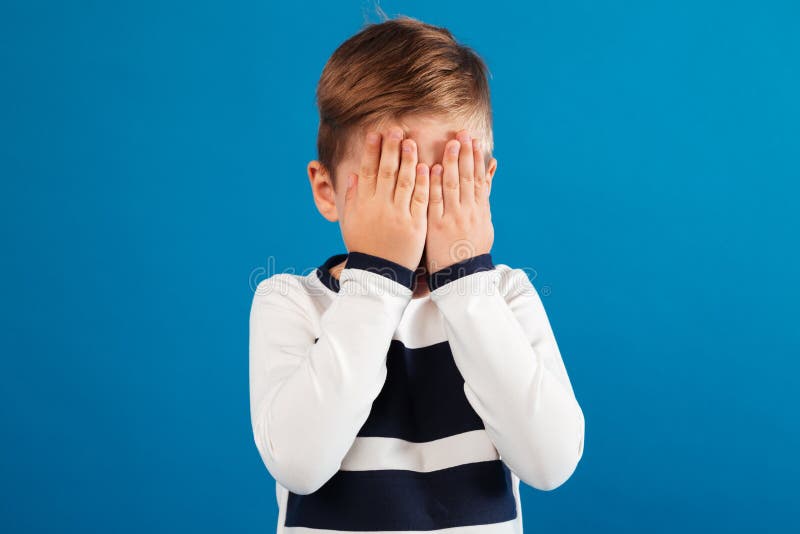 Image of Young Boy in Sweater Covering His Face Stock Photo - Image of ...