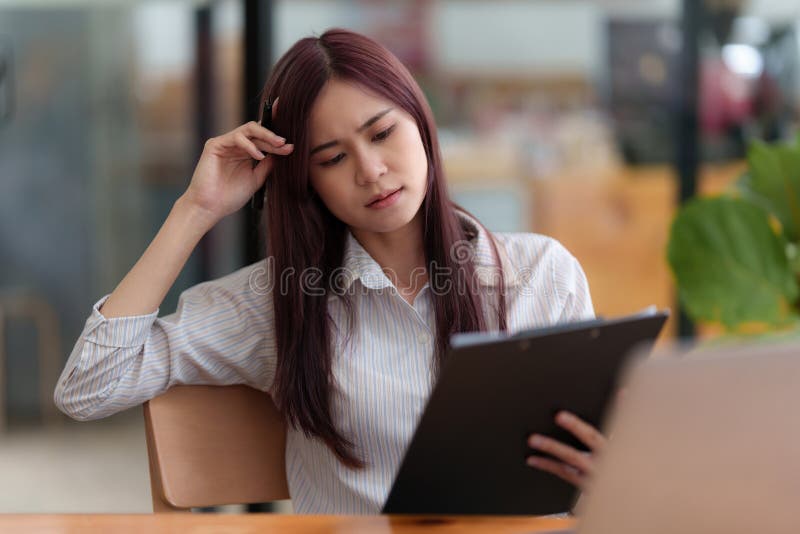Image of Young Woman Stressed while Reading a Book for Exam at Library ...
