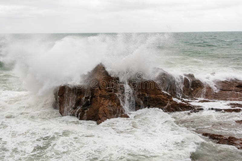 Immense Waves Hitting a Large Rock at the Edge of the Beach. Force of ...