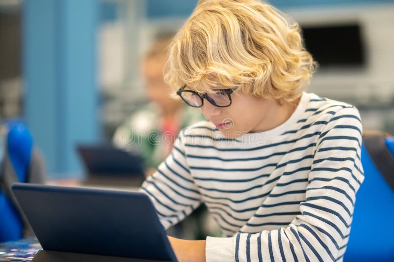 Boy Sitting Attentively Looking at the Tablet Stock Photo - Image of ...
