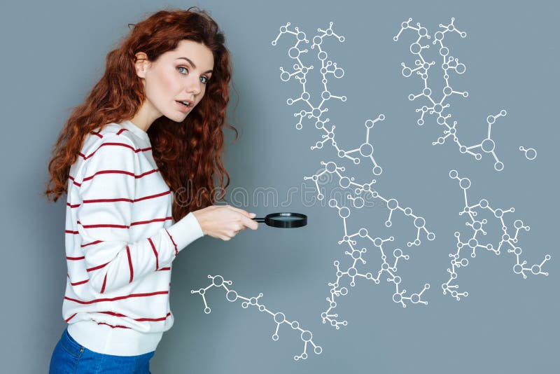 Skilled Scientist Holding a Magnifying Glass while Making an Experiment ...