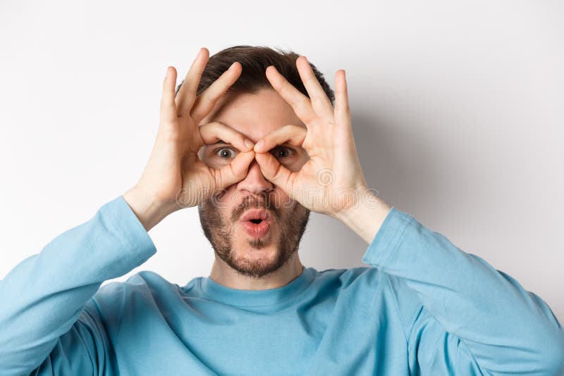 Impressed Caucasian Man Looking through Hand Binoculars with Amazed ...