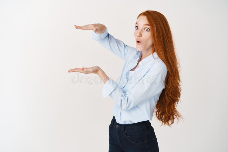 Impressed Redhead Woman Showing Big Object with Hands, Measuring ...