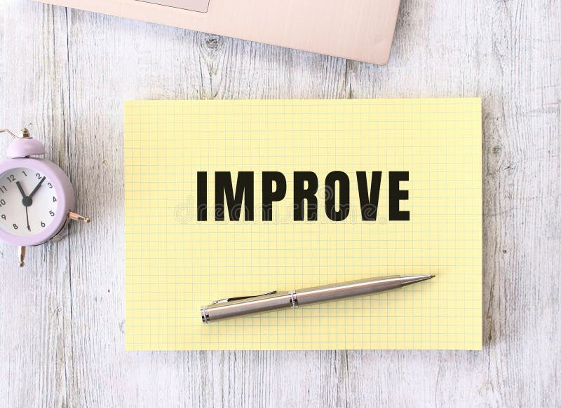 IMPROVE Text Written in a Notebook Lying on a Wooden Work Table Next To ...