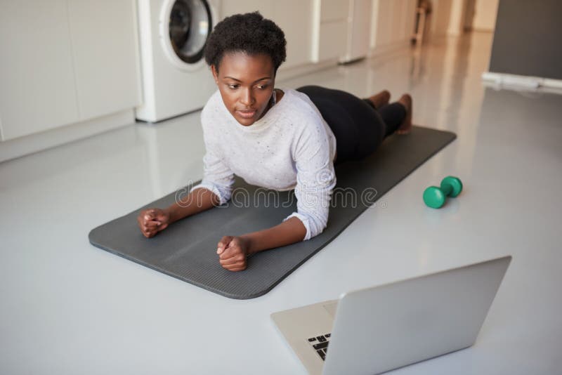 Improving Her Core Strength and Stability. a Young Woman Using a Laptop ...