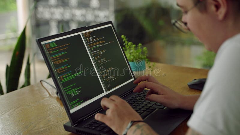 Focused Transgender Individual with Headphones Works on Laptop in a ...