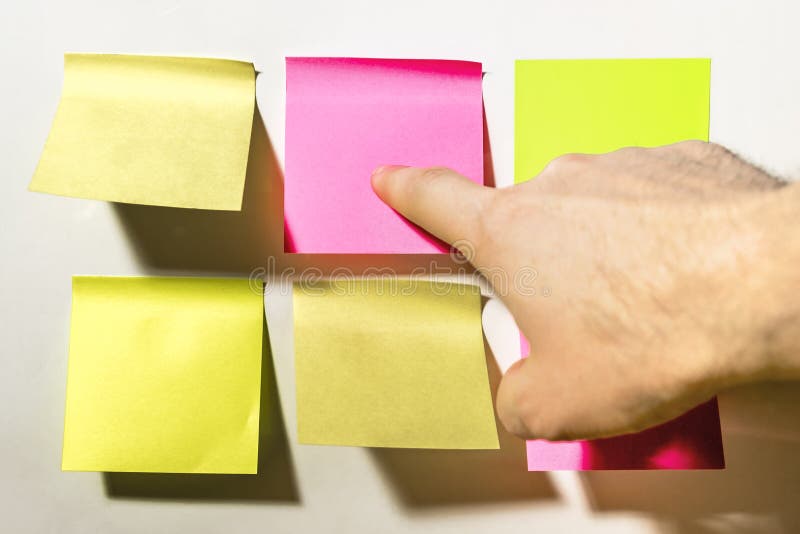 The Index Finger Points at the Colored Square Post-it Notes Pasted on ...