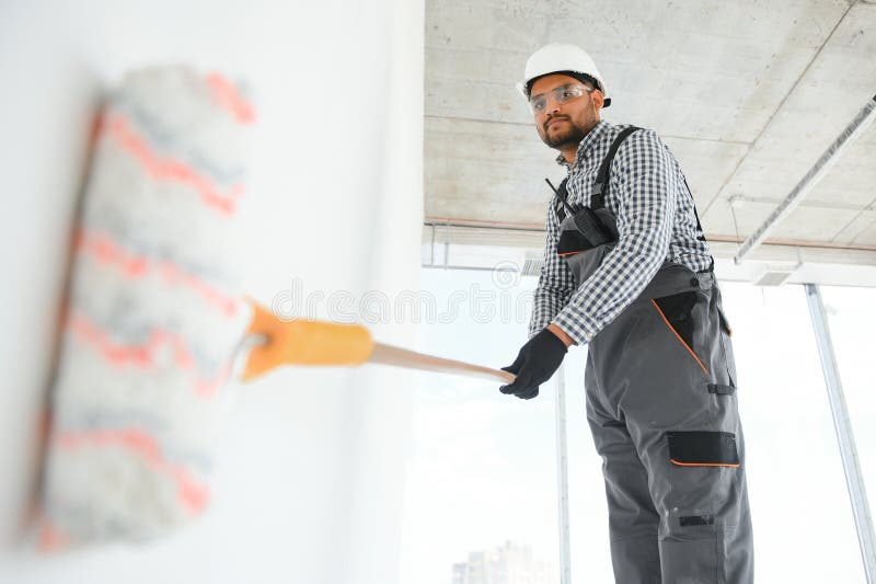 An Indian Apartment Repair Worker Paints a White Wall with a Roller ...
